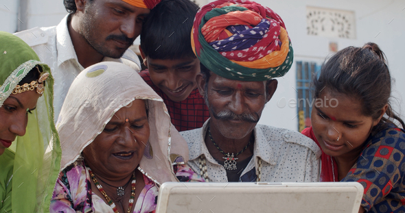 Group of South Asian people in traditional Indian clothing using a ...