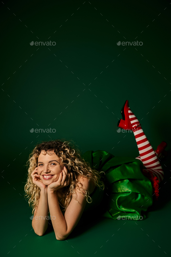 happy woman dressed as new year elf posing on floor with her legs ...