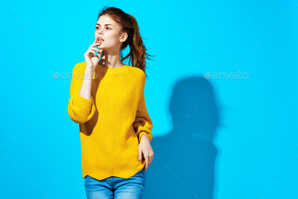pretty woman in yellow sweater emotions gestures hands studio blue ...