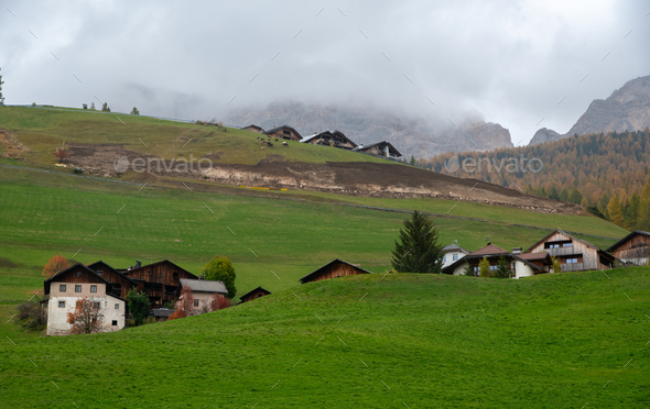 Traditional wooden cottage mountain houses in the green field in the ...