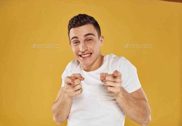 Man shows positive gestures with his hands fun yellow background ...