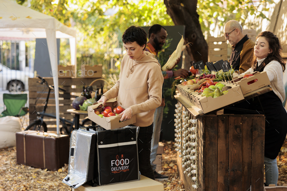 Food delivery worker putting fresh natural produce box in bag Stock ...