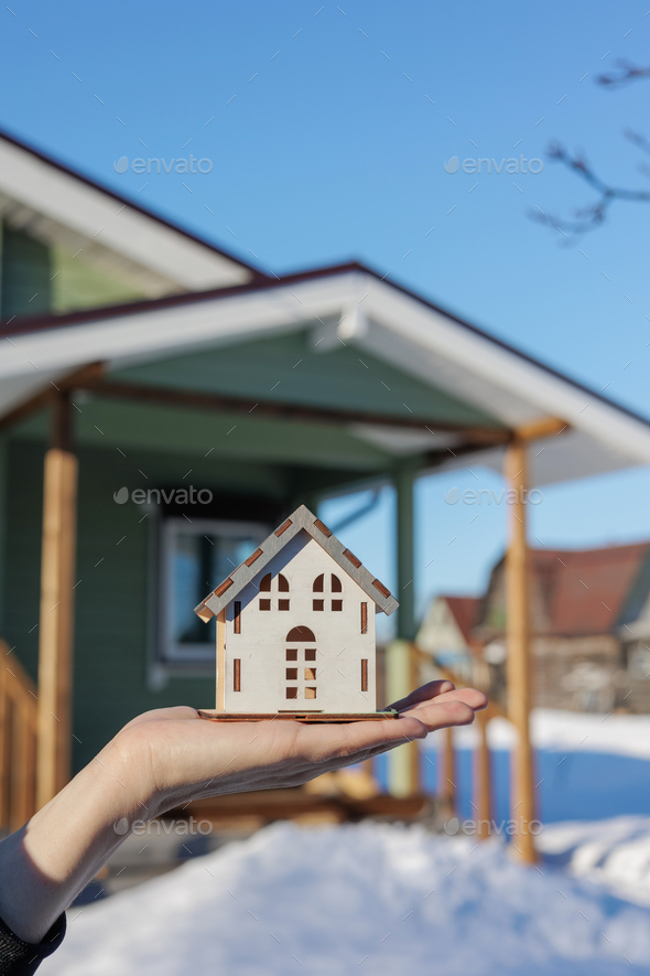 woman holds key and a model of mock-up of house in her hands. sale of ...