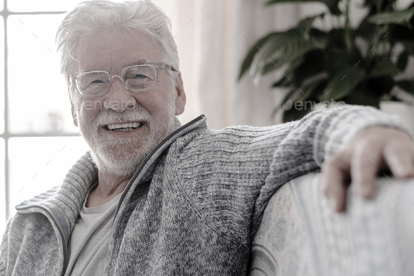 Smiling handsome senior caucasian man sitting on couch at home. Modern ...