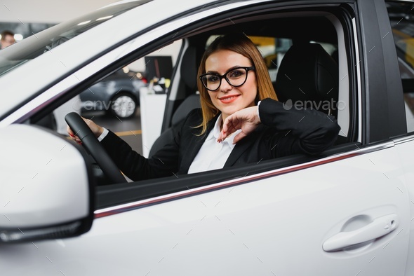 Young business woman driving in her car to work. Successful business ...