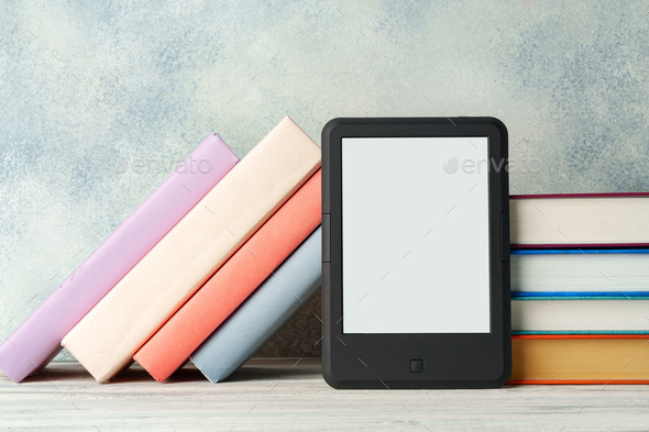 Digital tablet with a stack of books on gray background Stock Photo by ...