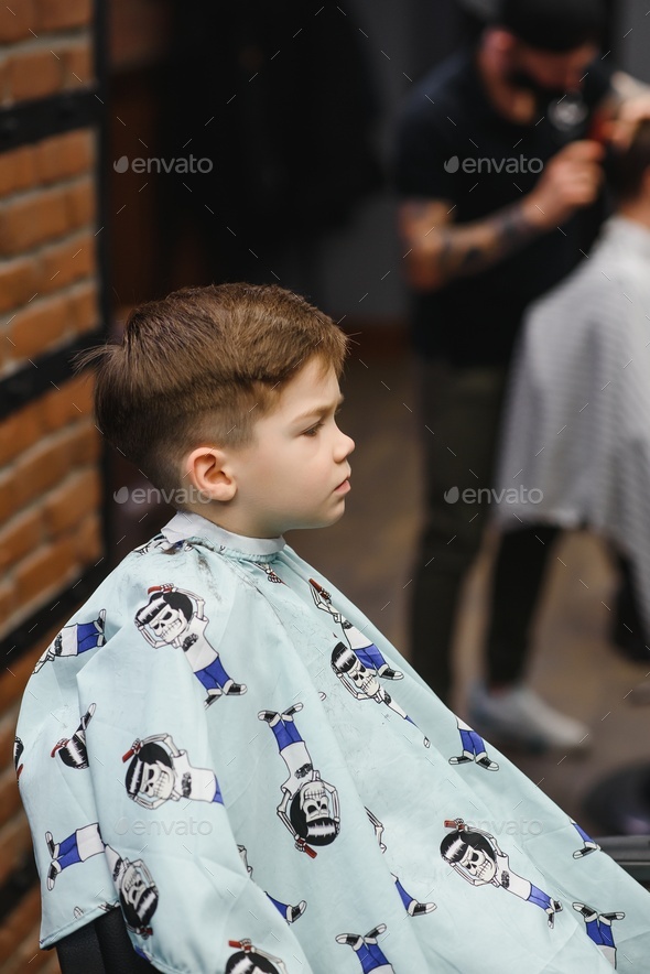 Cheerful Caucasian boy getting hairstyle in barbershop Stock Photo by ...