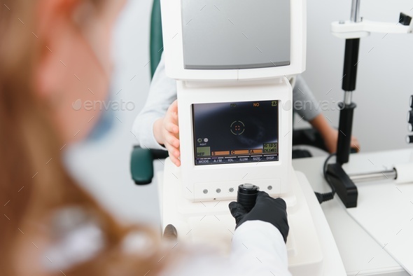 Close up of ophthalmologist using auto refractometer while examining ...