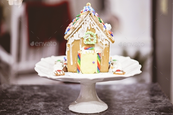 Delicious and decorated gingerbread house on the table with a blurred ...