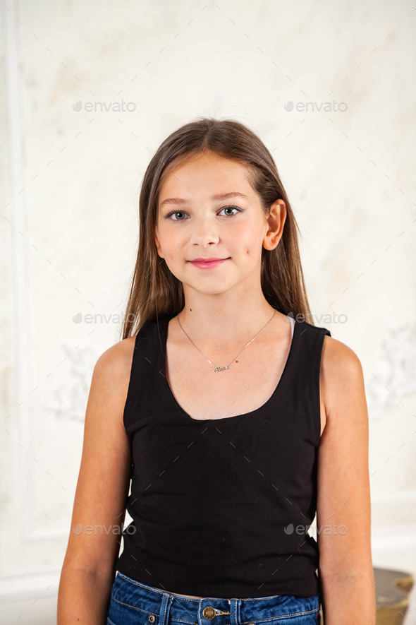 Portrait of pretty smiling teen girl 12 year old posing in living room ...