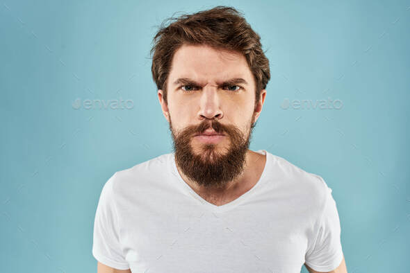 Bearded man in white T-shirt emotions gestures with hands displeased ...