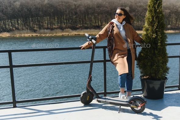 beautiful woman riding an electric scooter to work, modern girl, new ...