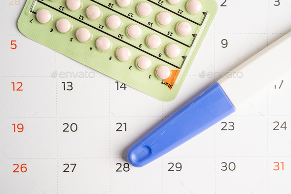 Pregnancy test and birth control pills on calendar, contraception ...