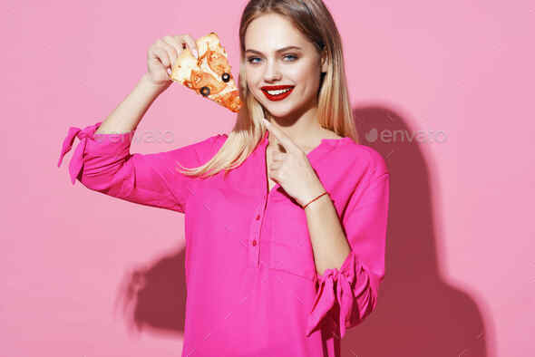 blonde eating pizza fast food pink background Stock Photo by shotprime
