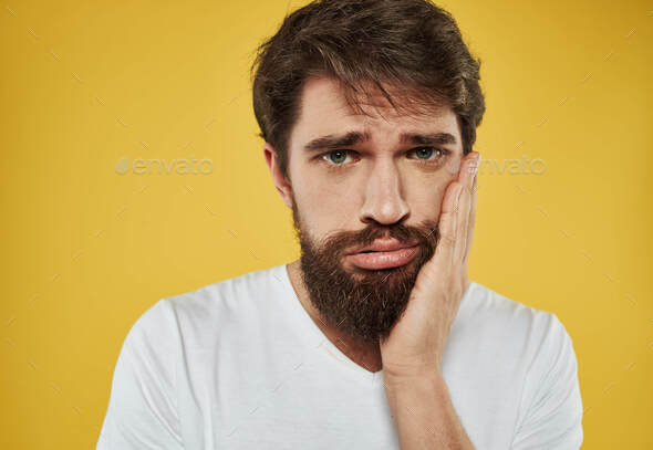 sad man on a yellow background in a white t-shirt beard model Stock ...
