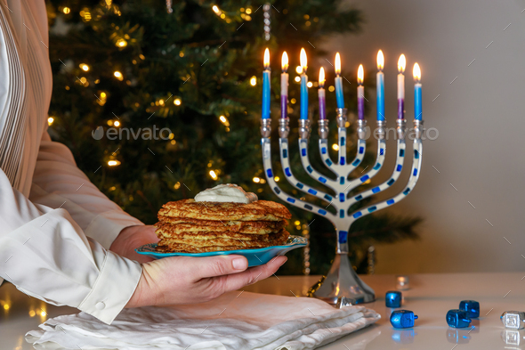 Menorah and potato latkes on Jewish holiday table during Hanukkah ...