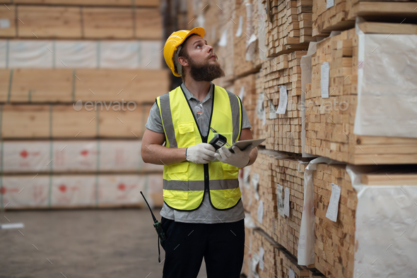 Warehouse staff verify wooded pallets items using handheld device ...