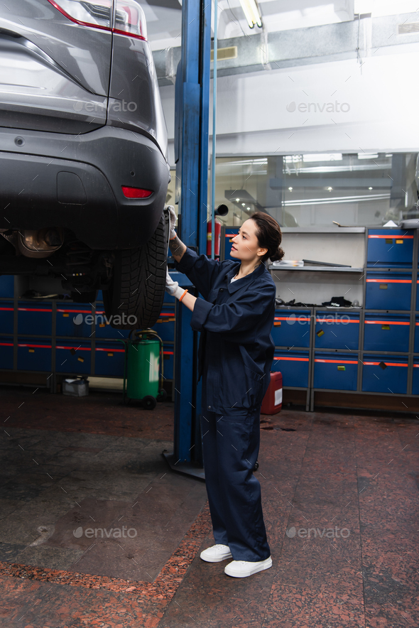 Mechanic setting disk on wheel of car in service Stock Photo by ...