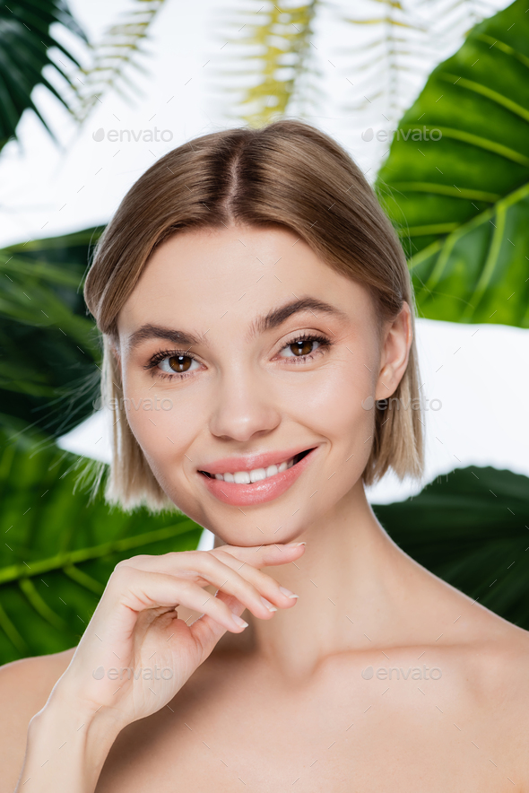 Joyful Young Woman With Perfect Skin Near Green Tropical Leaves On
