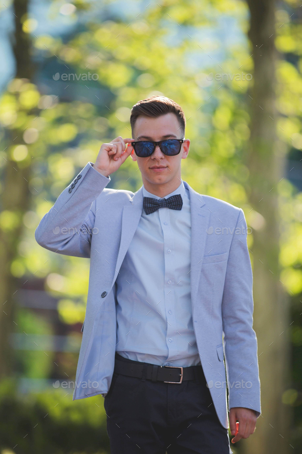 Handsome male with a suit and sunglasses posing outdoors Stock Photo by ...