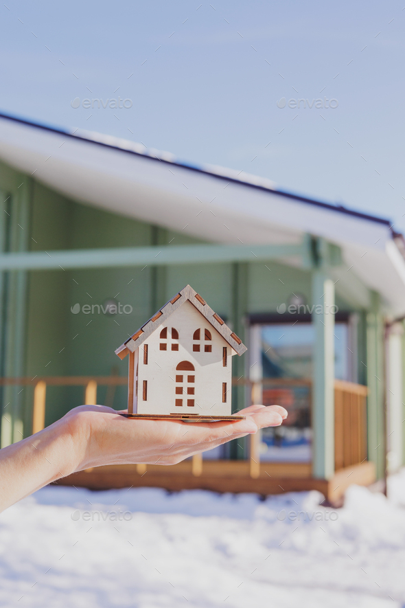 woman holds key and a model of mock-up of house in her hands. sale of ...