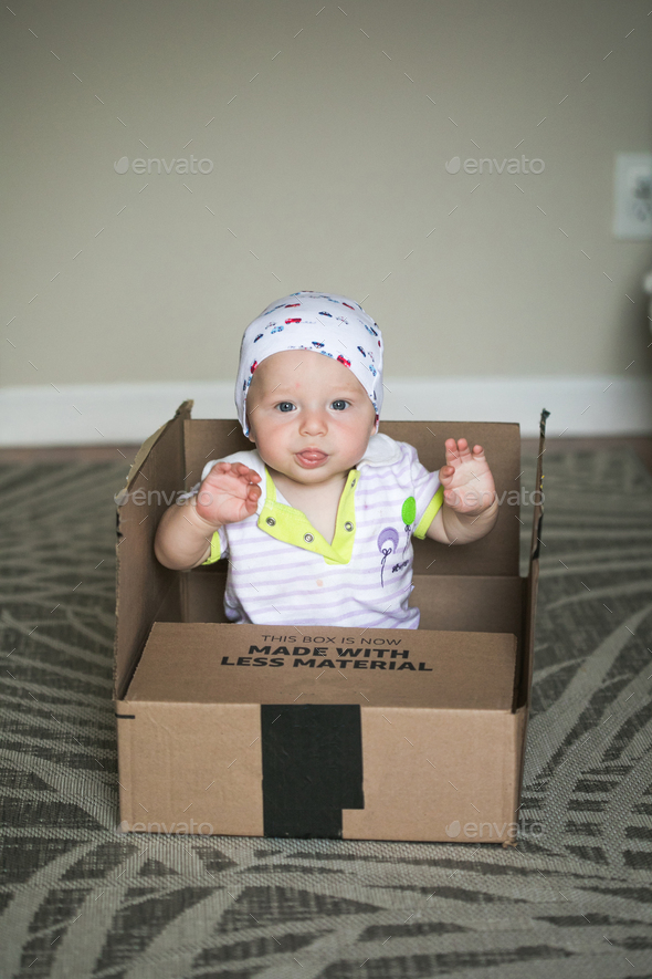 pretty child baby boy sitting inside a box Stock Photo by sokorspace