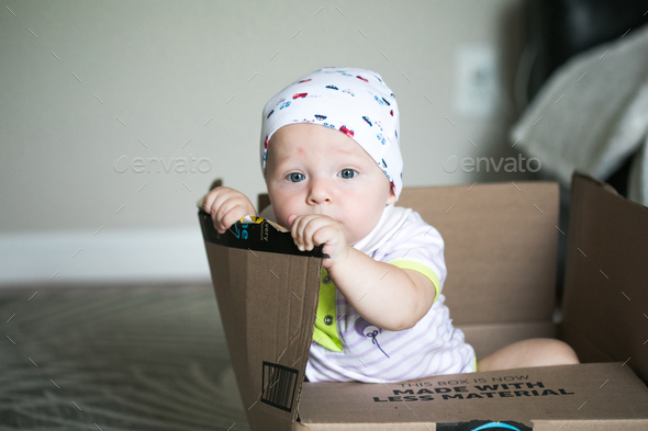 pretty child baby boy sitting inside a box Stock Photo by sokorspace