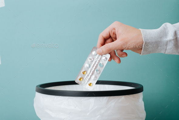 Close-up of hand throwing pack of pill capsules into trash, side view ...