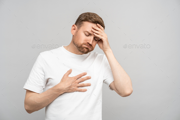 Man suffers from heartburn, nausea and pain in head. Guy holds head ...