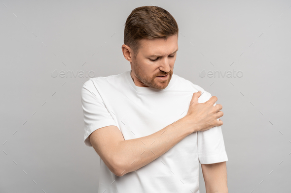 Unhealthy man holds on to sore shoulder. Guy experiences throb pain in ...
