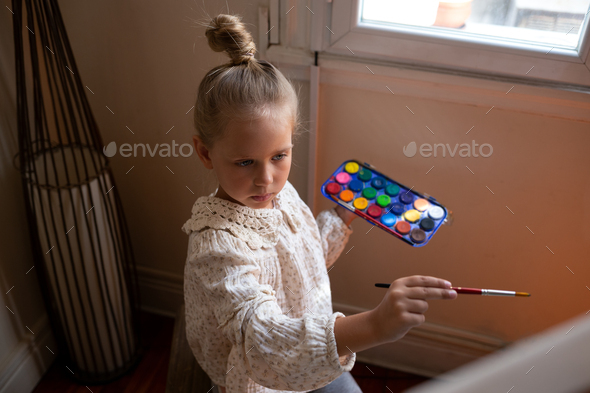 girl draws on canvas at the easel. the concept of early development of ...