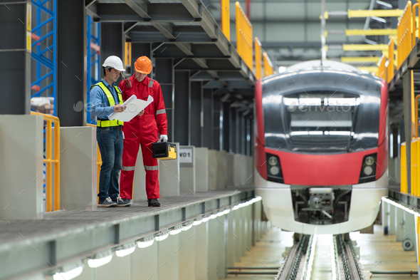 Electric train engineer and technician with tools inspect the railway ...