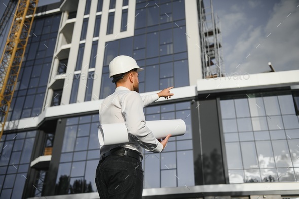 Engineer next to building cranes. Concept - large construction project ...