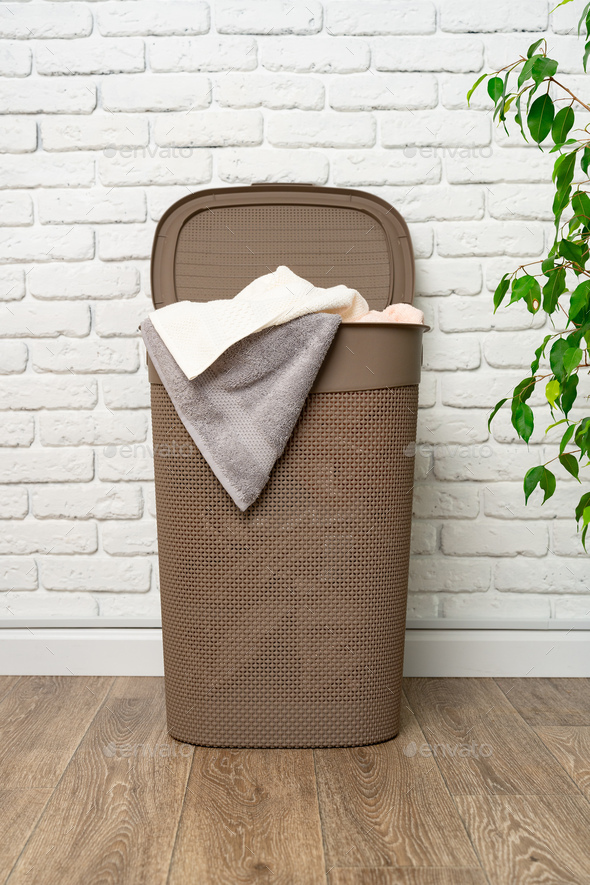 Pile of clothes in plastic laundry basket in the bathroom Stock Photo ...