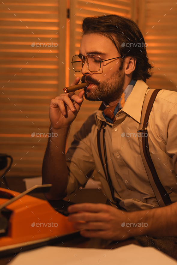 writer with mustache and eyeglasses smoking cigar near retro typewriter ...
