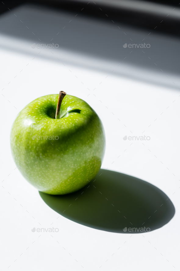 close up of green apple with shadow on white Stock Photo by ...