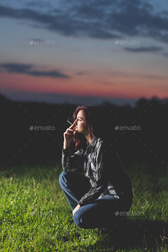 Attractive Caucasian female smoking cigarette outdoor during the ...