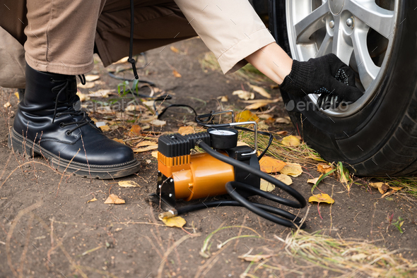 man driver hand inflating tires of vehicle, removing tire valve ...
