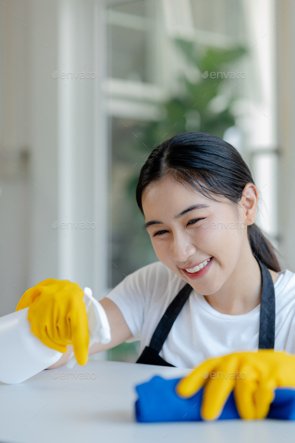 Asian female cleaner wiping down tables with cleaning spray, Wear ...