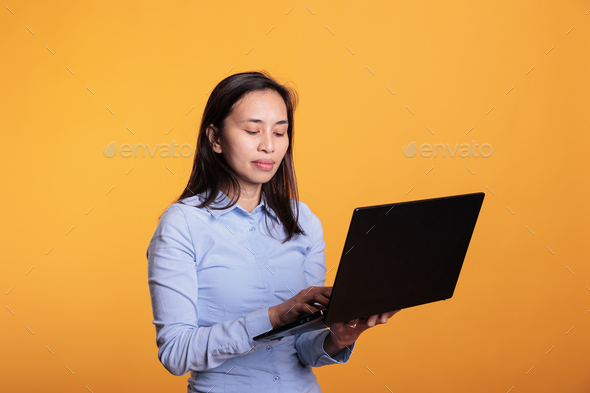 Filipino woman using laptop computer browsing webpages Stock Photo by ...