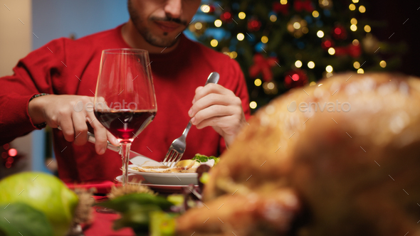 Man eating roasted turkey for thanksgiving day Stock Photo by PolonioVideo