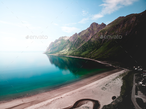 Beautiful beach of Senja island with reflection of the cliffs seen on ...