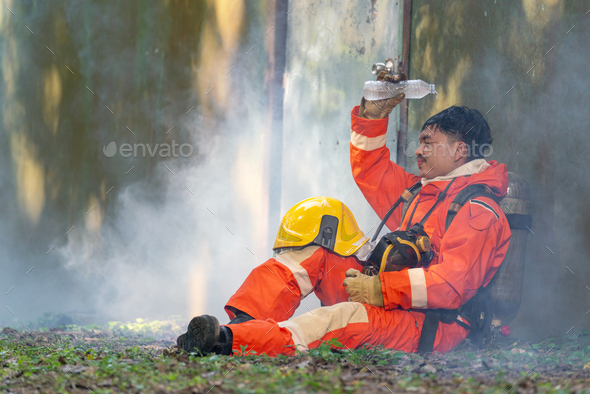 Firefighter Resting and Drinking Water After a Grueling Rescue ...