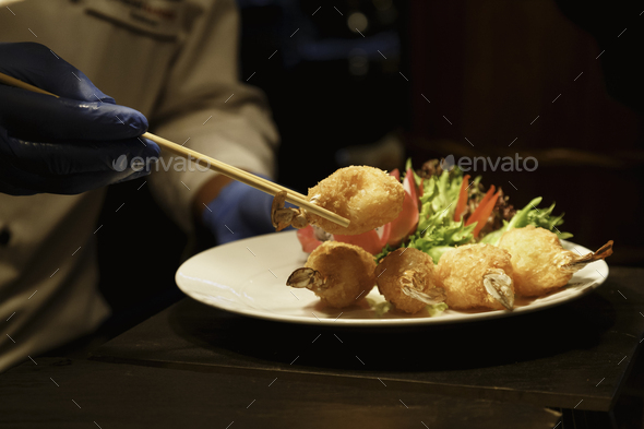 chef cooking and using chopsticks to decorating delicious dish for ...