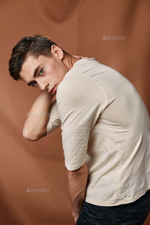 A man posing for a photo a fashionable hairstyle, an attractive look ...