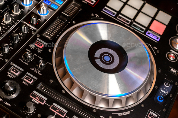 Disc Jockey DJ mixing deck and turntables with controls for mixing ...