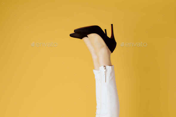 inverted female legs in black shoes posing yellow background Stock ...