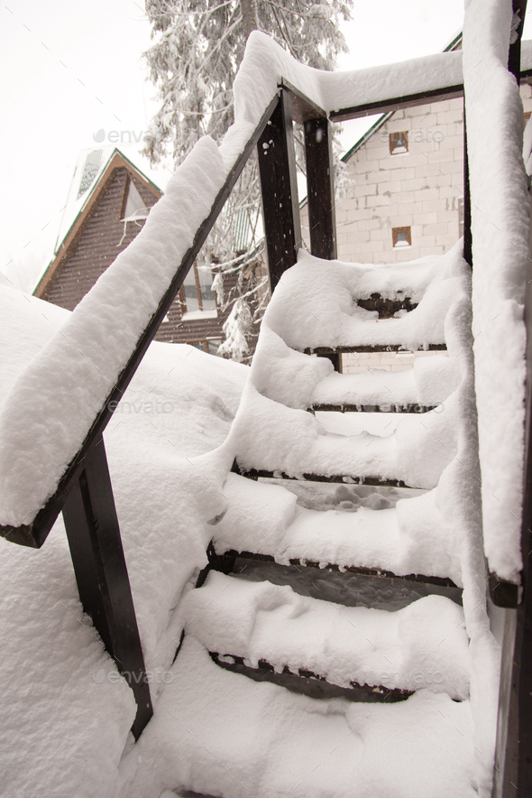 Winter snow stairs. Wooden staircase of a private house. A lot of snow ...