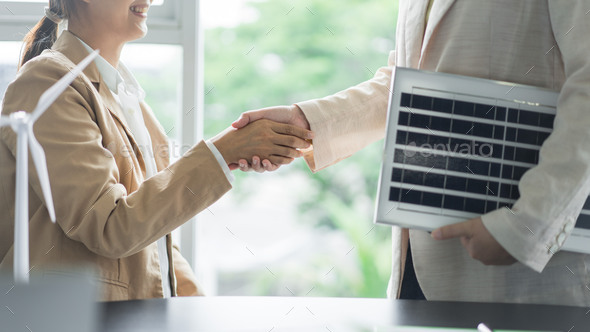 Alternative energy environment businesspeople shake hands after deal ...