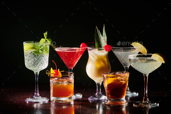 set of different sophisticated cocktails with fresh garnishing on black ...